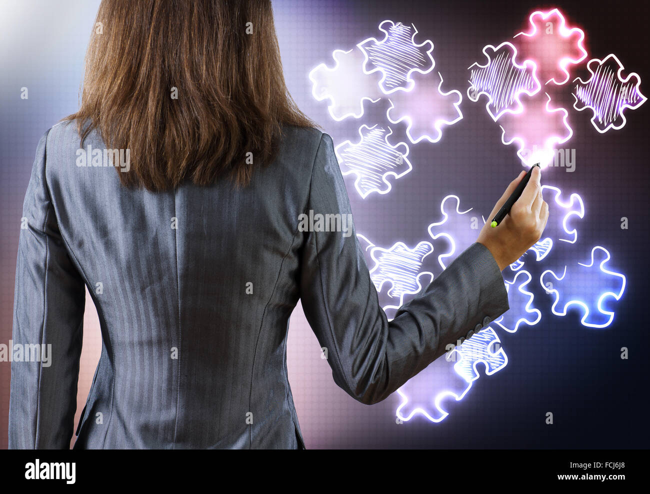 Rear view of businesswoman drawing puzzles with pen Stock Photo - Alamy