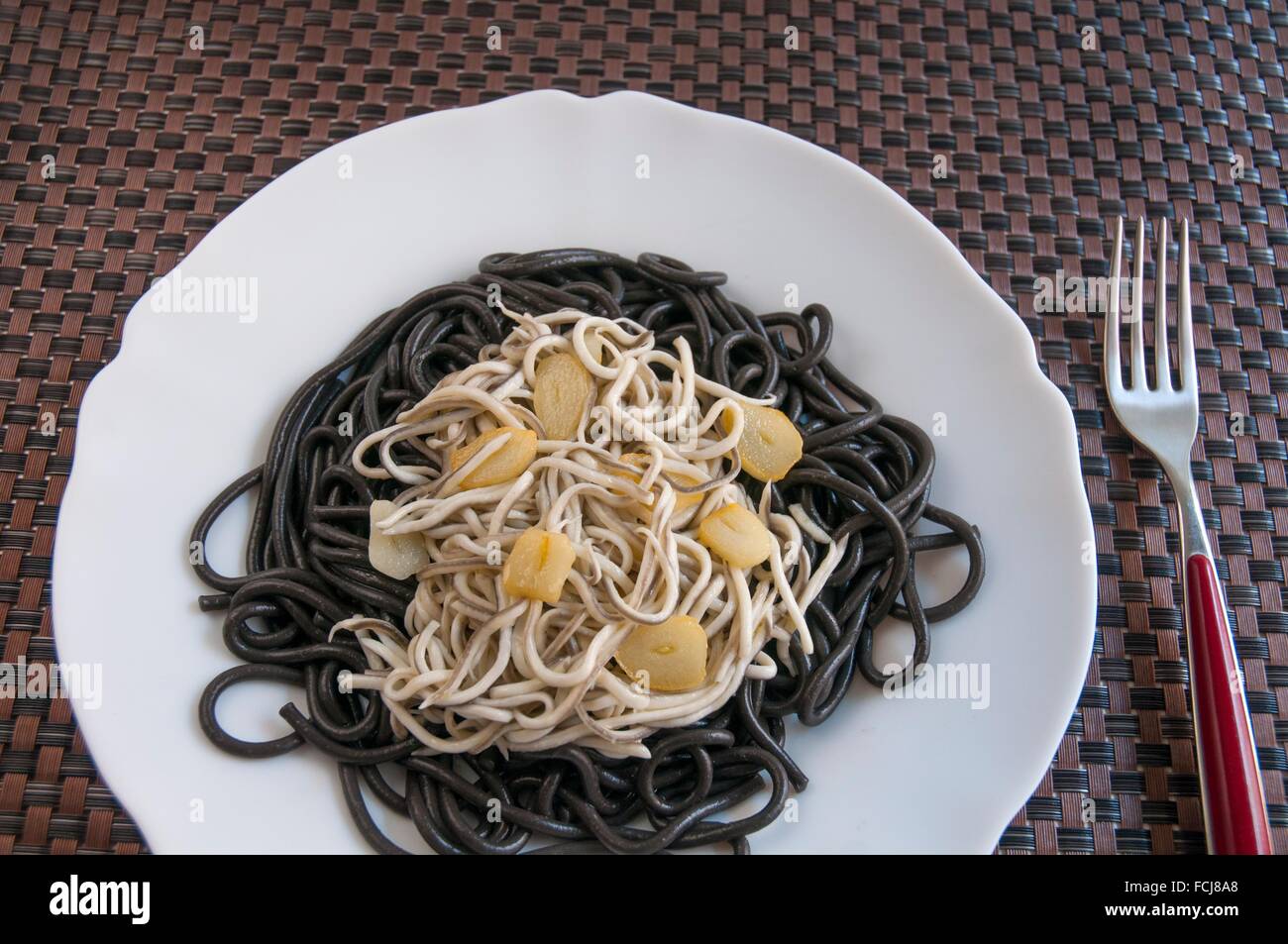 Black spaghetti with eels and garlic Stock Photo - Alamy