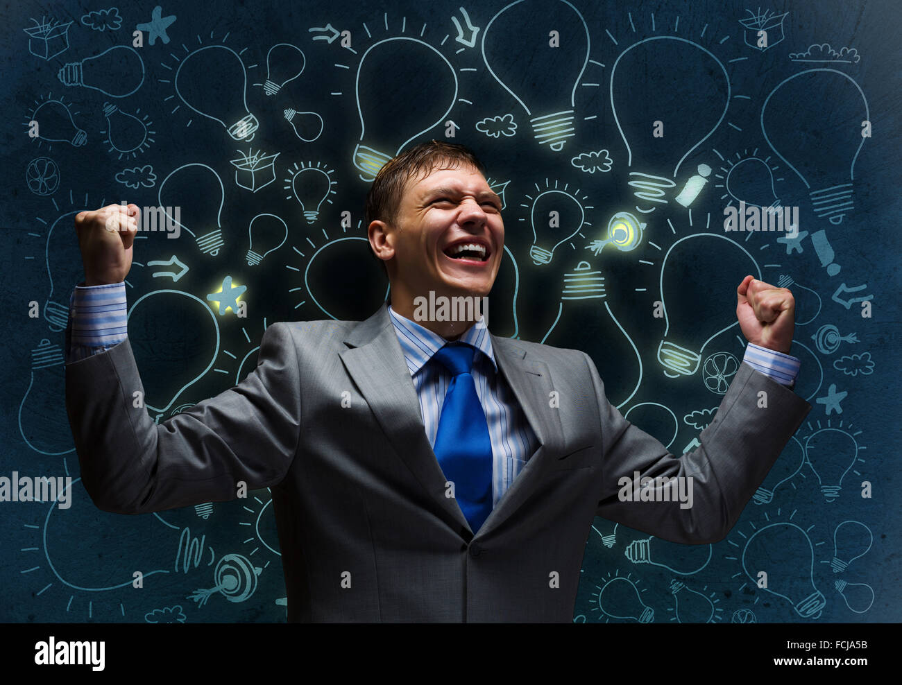 Young joyful businessman with hands up celebrating success Stock Photo ...