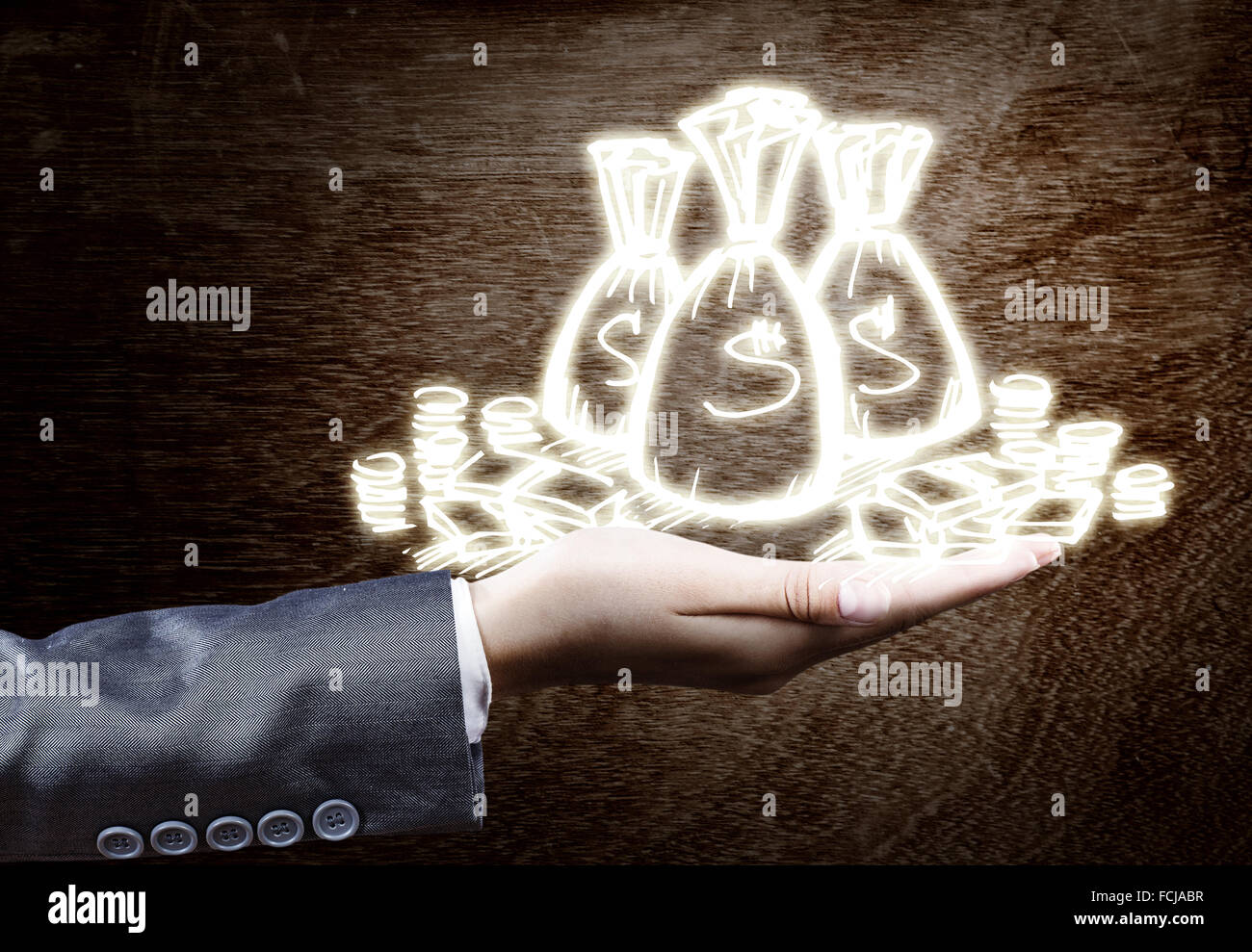 Close up of businessperson hand holding money bags Stock Photo - Alamy