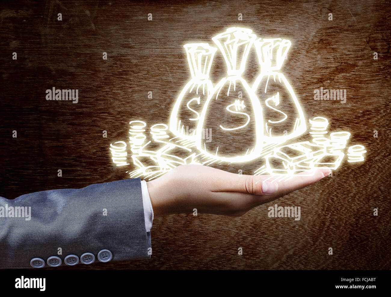 Close up of businessperson hand holding money bags Stock Photo - Alamy
