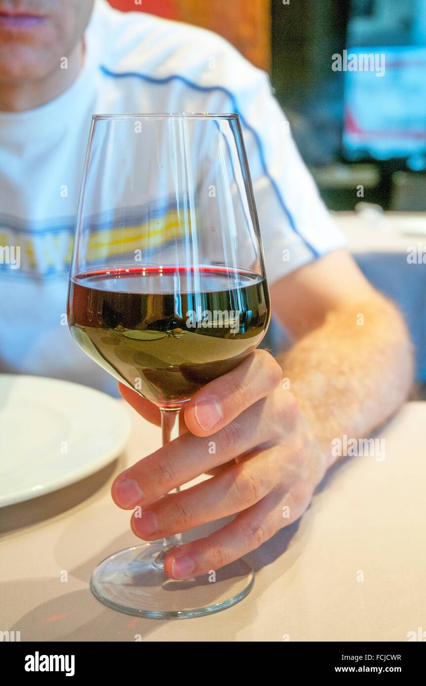 Man´s hand holding a glass of red wine. Close view Stock Photo - Alamy