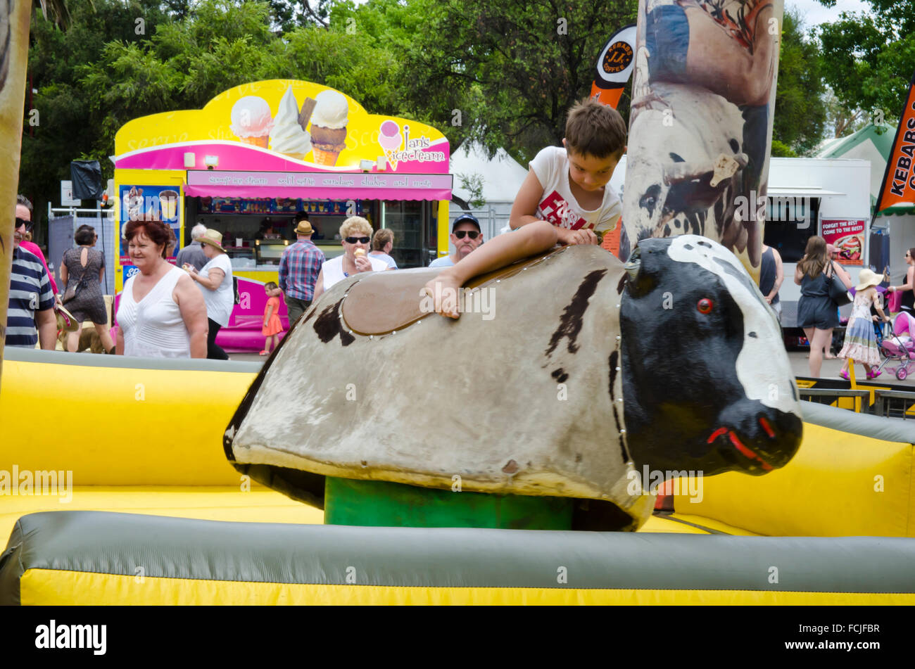 Young boy about to fall off a bucking mechanical bull Stock Photo - Alamy