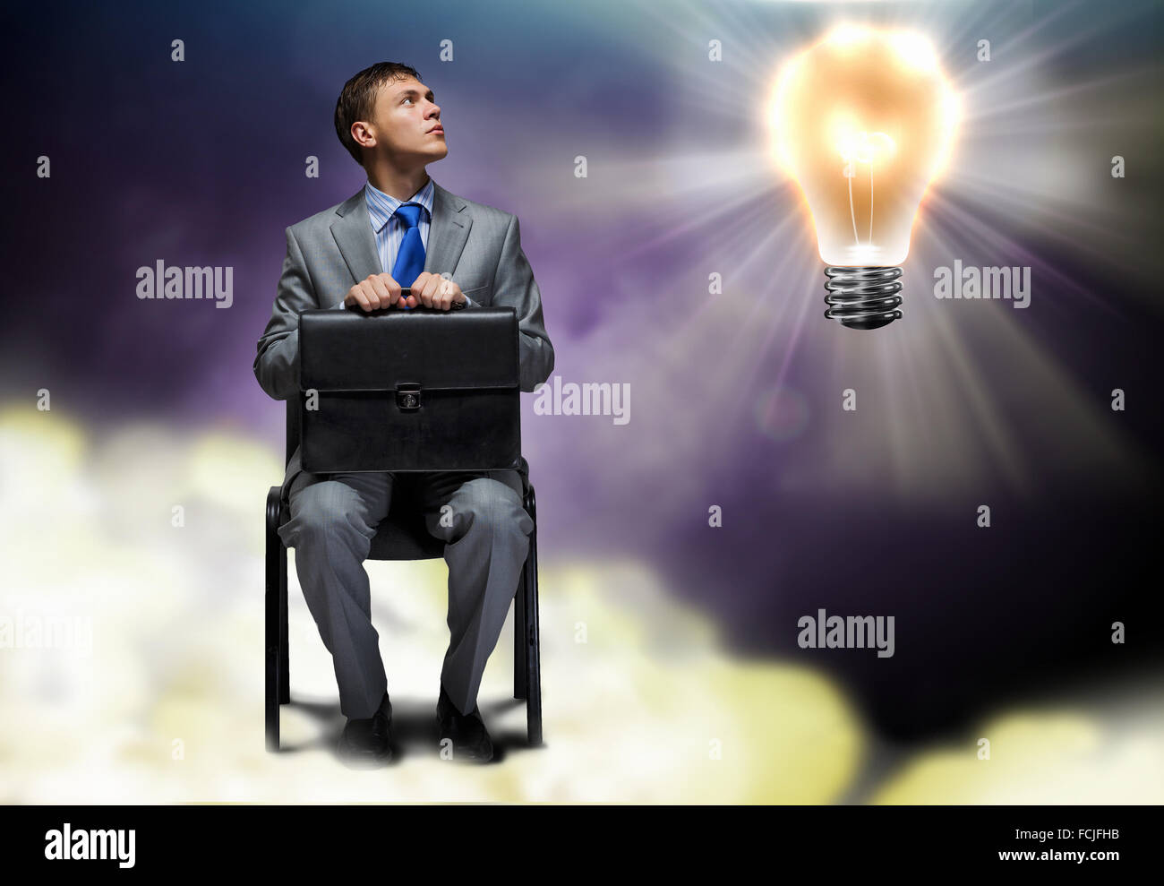 Businessman sitting on chair and looking on light bulb Stock Photo - Alamy
