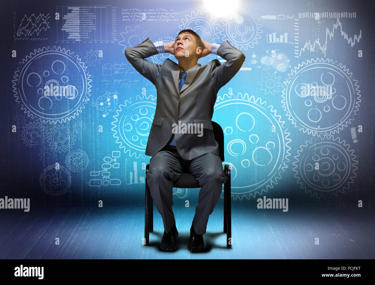 Young businessman sitting on chair and looking above Stock Photo - Alamy