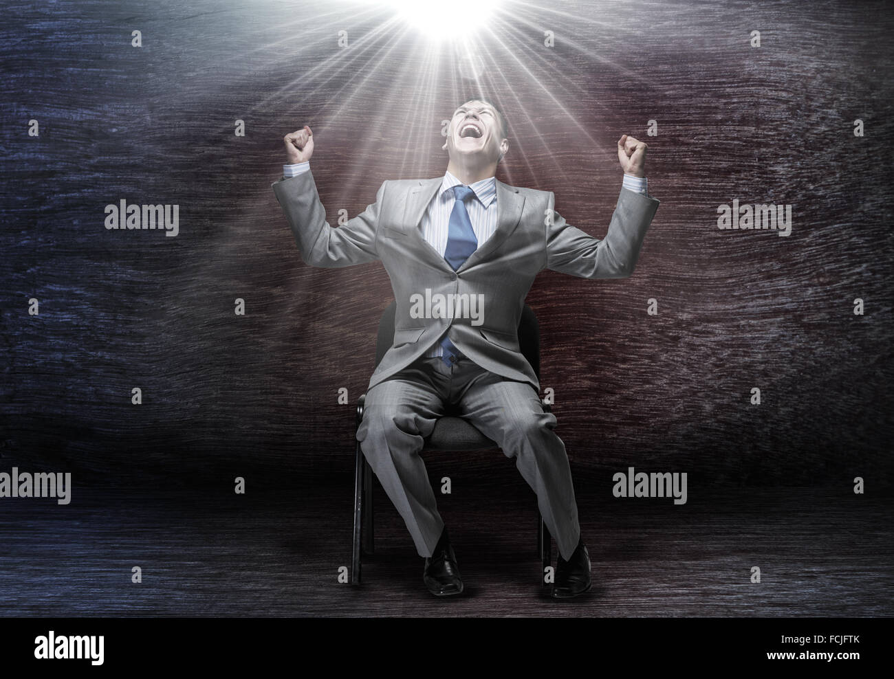 Emotional businessman sitting on chair and screaming ahead Stock Photo ...