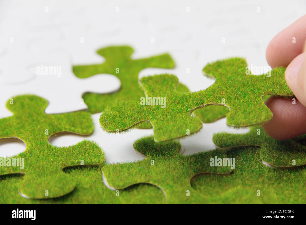 hand holding a green puzzle piece, green space concept Stock Photo - Alamy