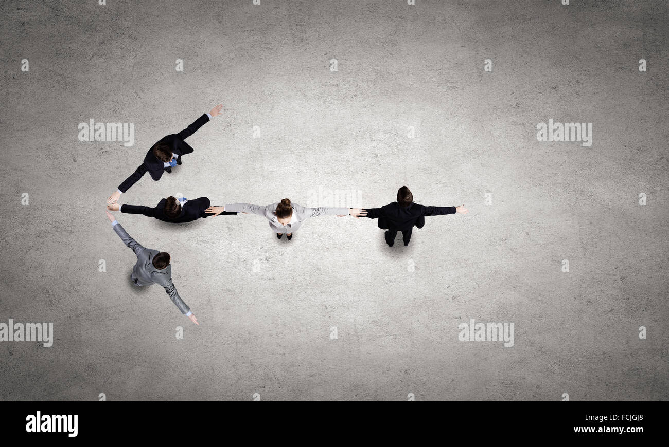 Business people with stretched arms making figure of arrow Stock Photo ...