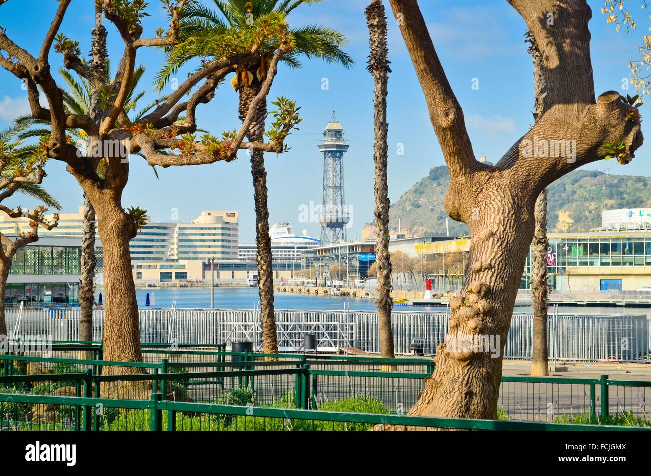 Aerial tramway tower among trees. Cable-car tower at harbour. Port vell ...