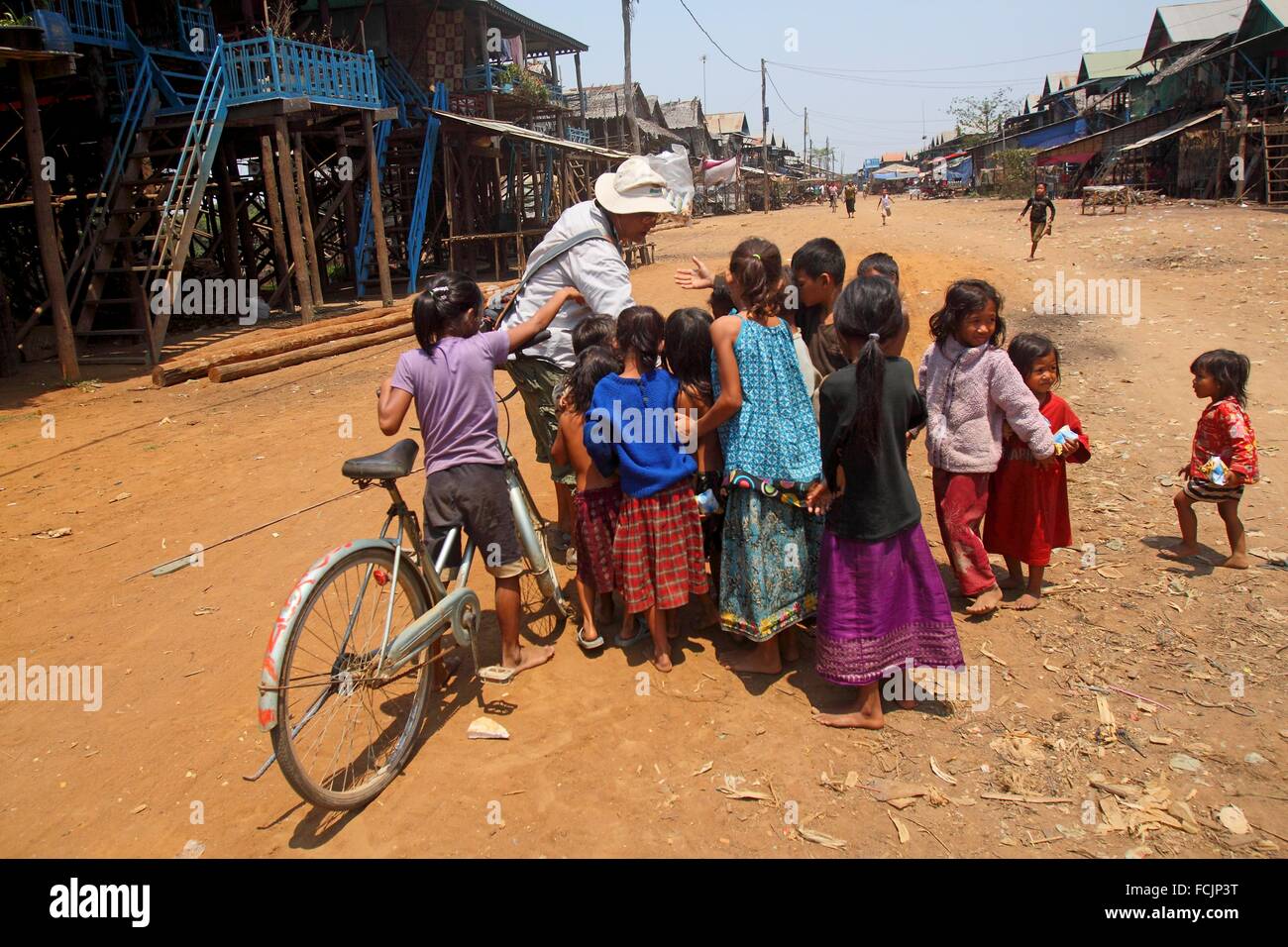 Tourist giving snack to children at kampong phulk, tonle sap lake, siem ...