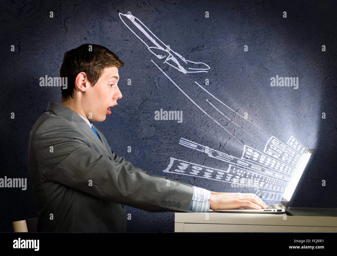 Young man looking in laptop screen with shock Stock Photo - Alamy
