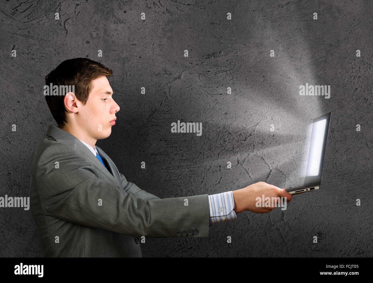 Young man thoughtfully looking in laptop screen Stock Photo - Alamy