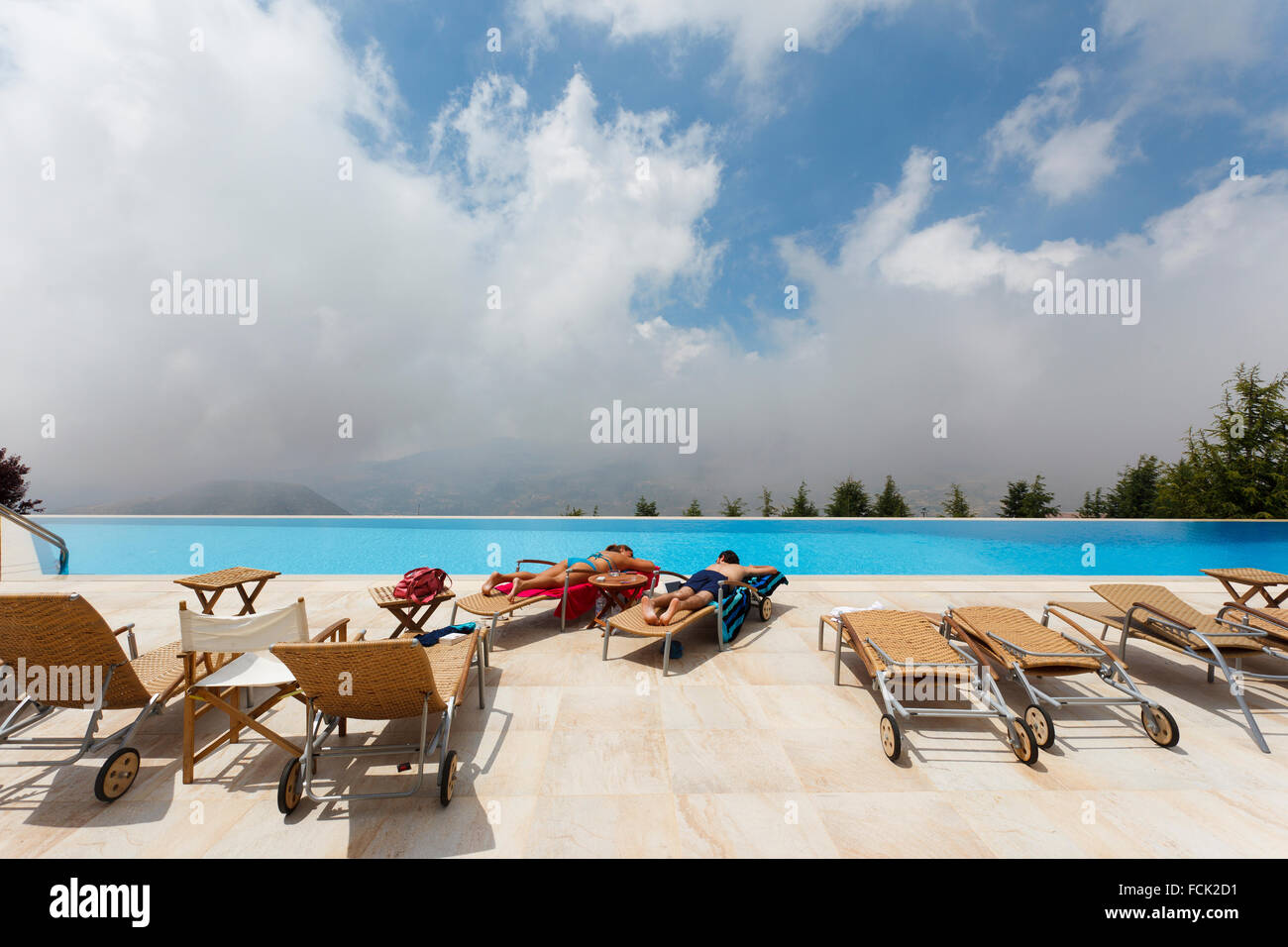 Couple lying in the sun at hotel swimming pool in Faraya, Lebanon Stock ...