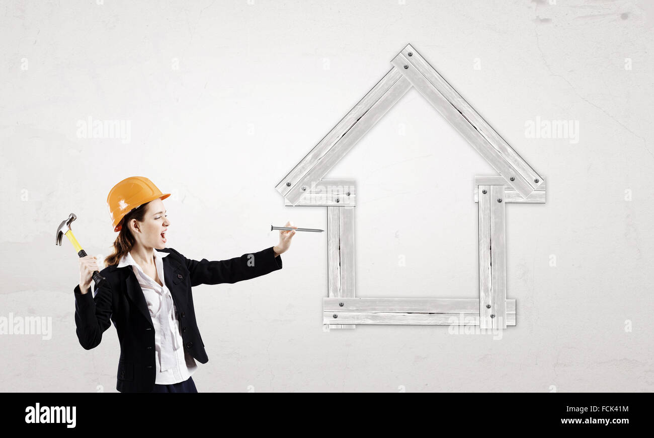 Young woman builder with hammer and nail in hand Stock Photo - Alamy