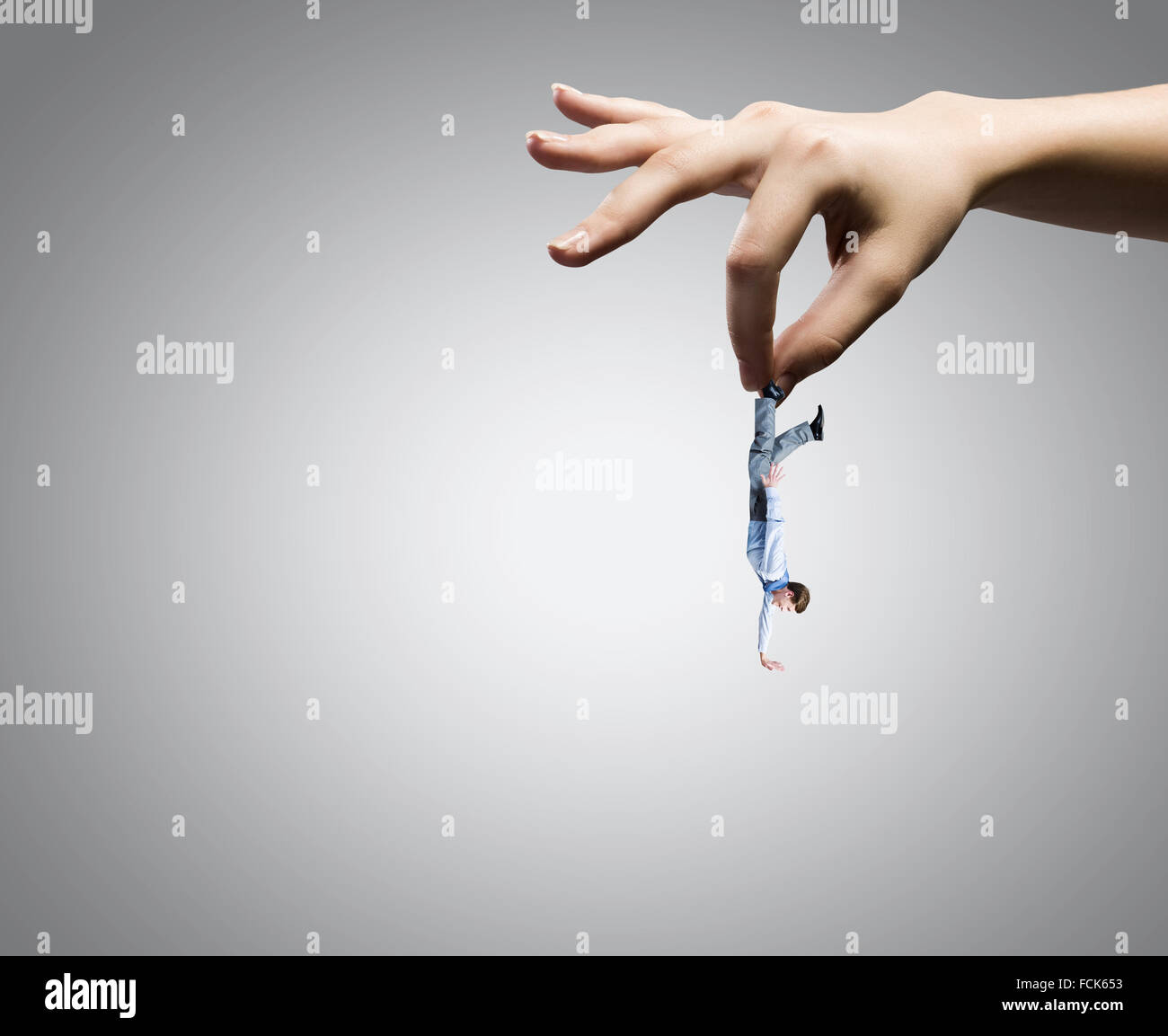 Close up of big human hand catching businessman Stock Photo - Alamy