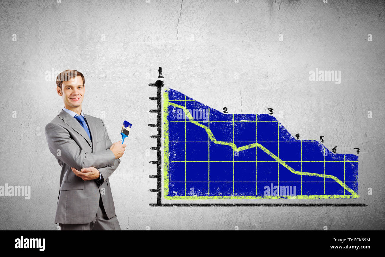 Young businessman painting graphs and diagrams with brush Stock Photo ...