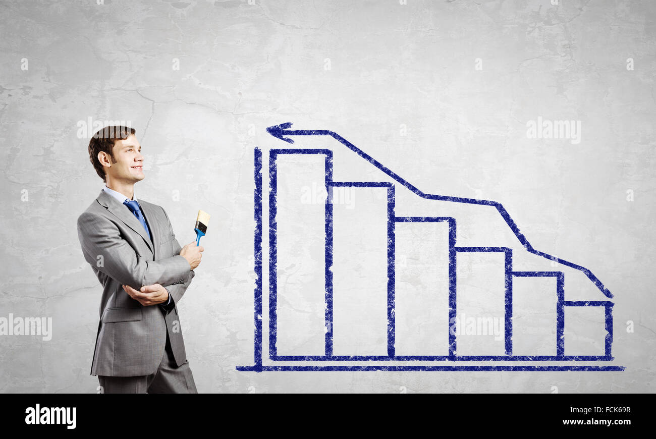 Young businessman painting graphs and diagrams with brush Stock Photo ...