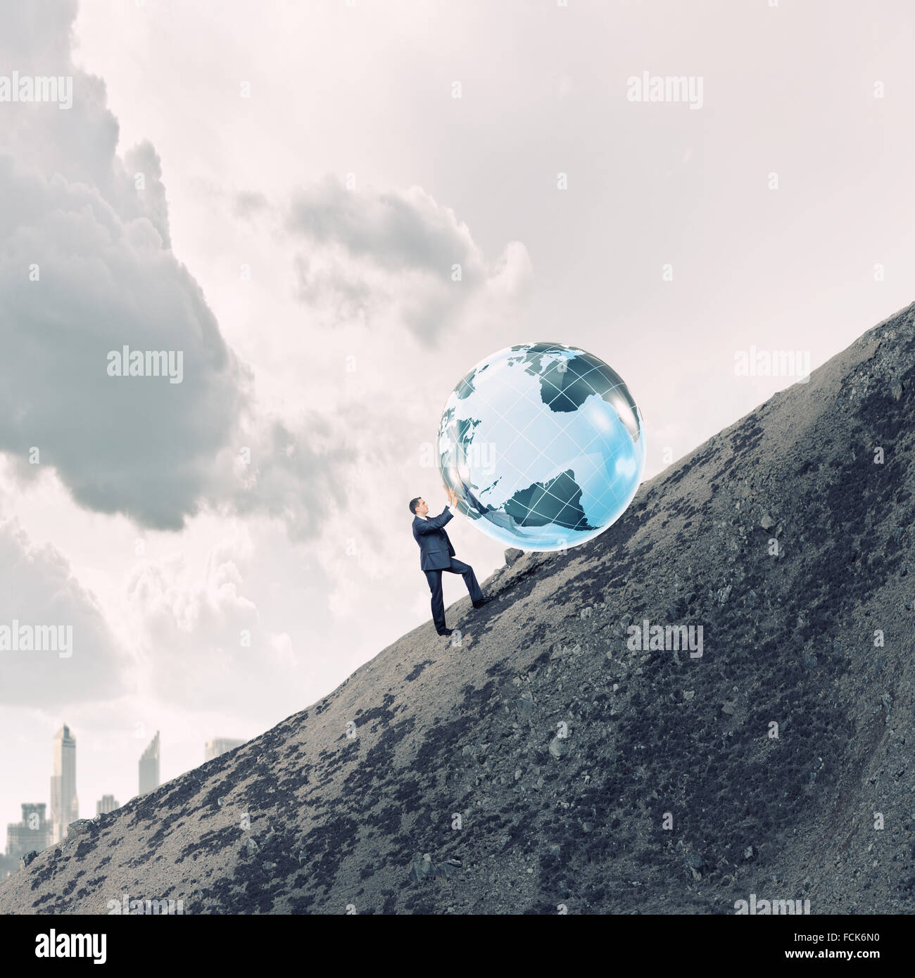 Young businessman rolling Earth planet up th hill Stock Photo - Alamy