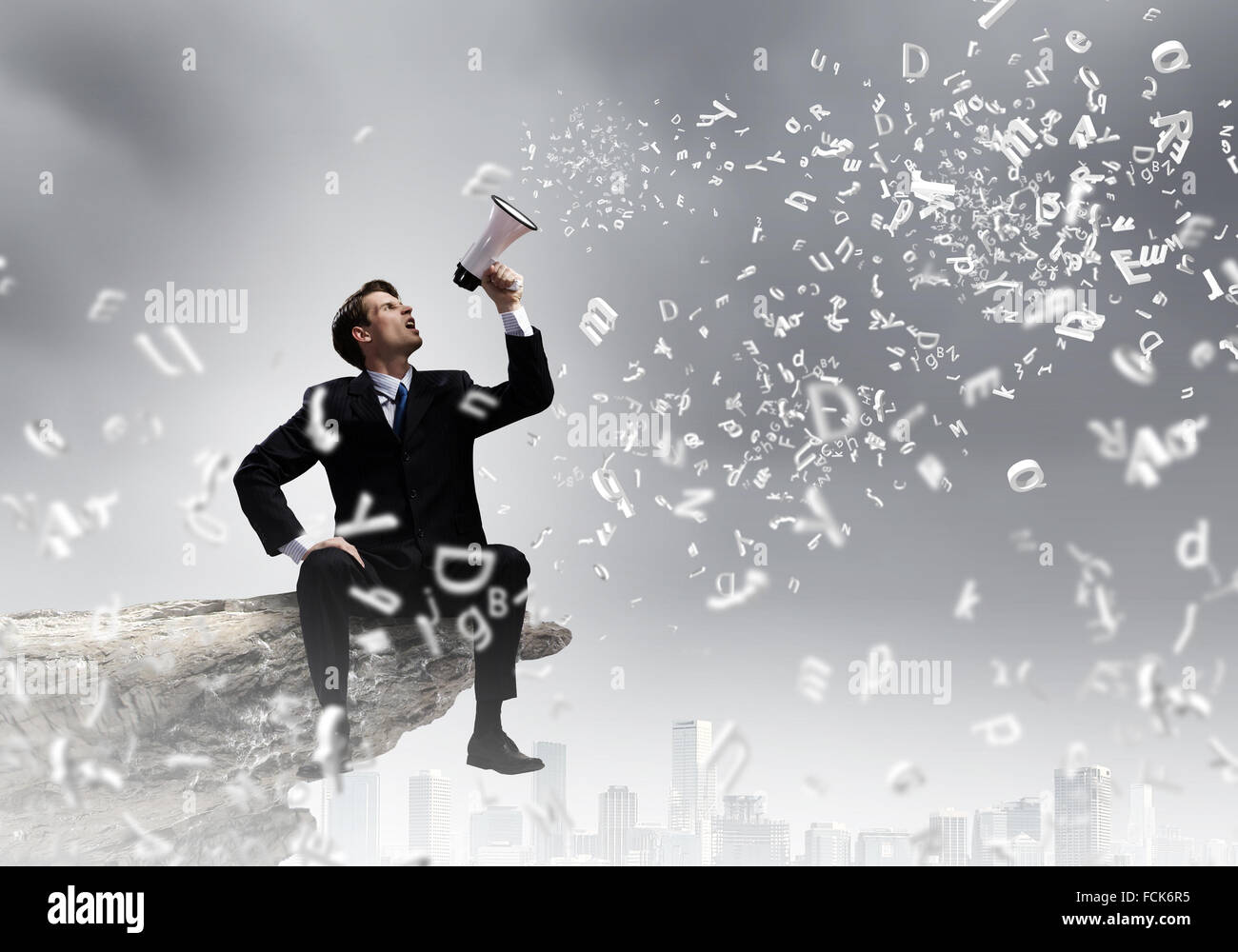 Young businessman on top of rock screaming in megaphone Stock Photo - Alamy