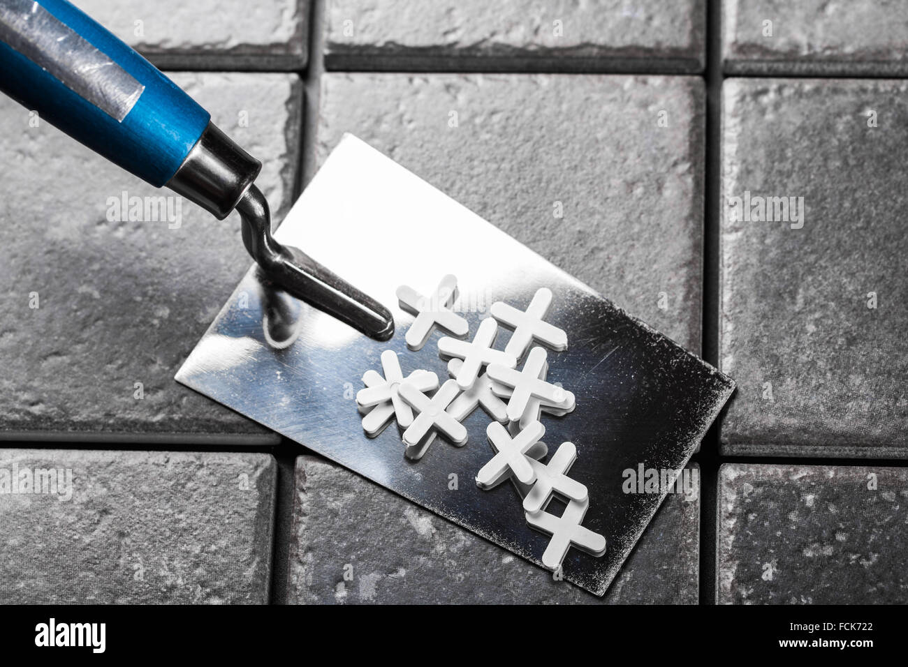 the trowel closeup on a background of ceramic tile Stock Photo - Alamy