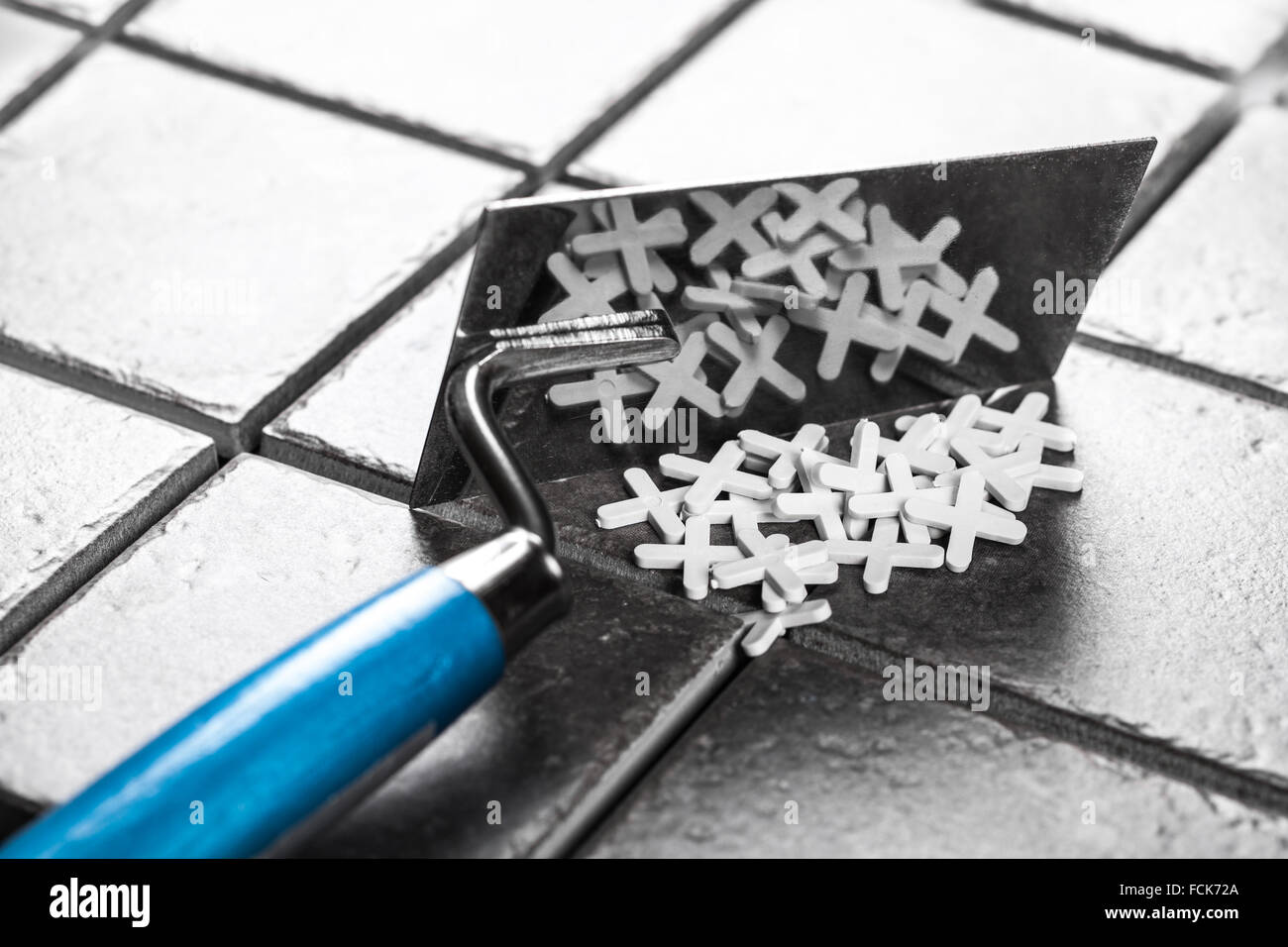 the trowel closeup on a background of ceramic tile Stock Photo - Alamy