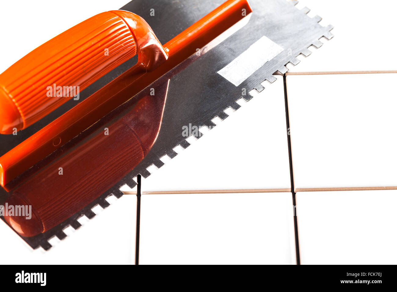 the trowel closeup on a background of ceramic tile Stock Photo - Alamy