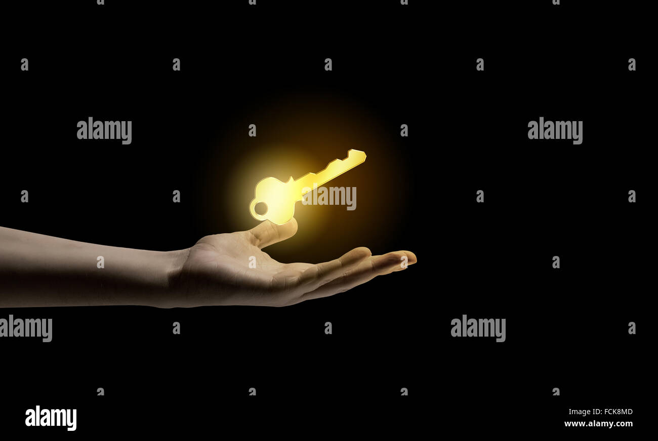 Close up of human hand holding golden key Stock Photo - Alamy
