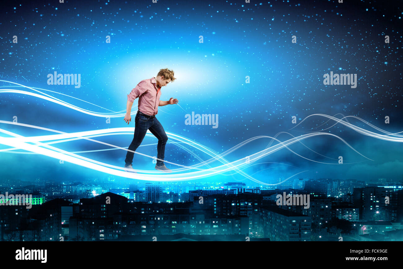 Young man walking on light rays in sky Stock Photo - Alamy