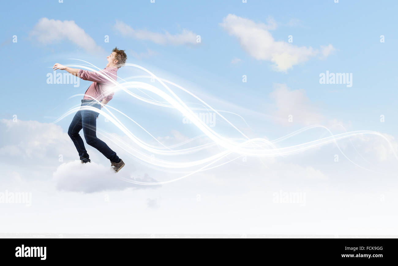Young man walking on cloud high in sky Stock Photo - Alamy