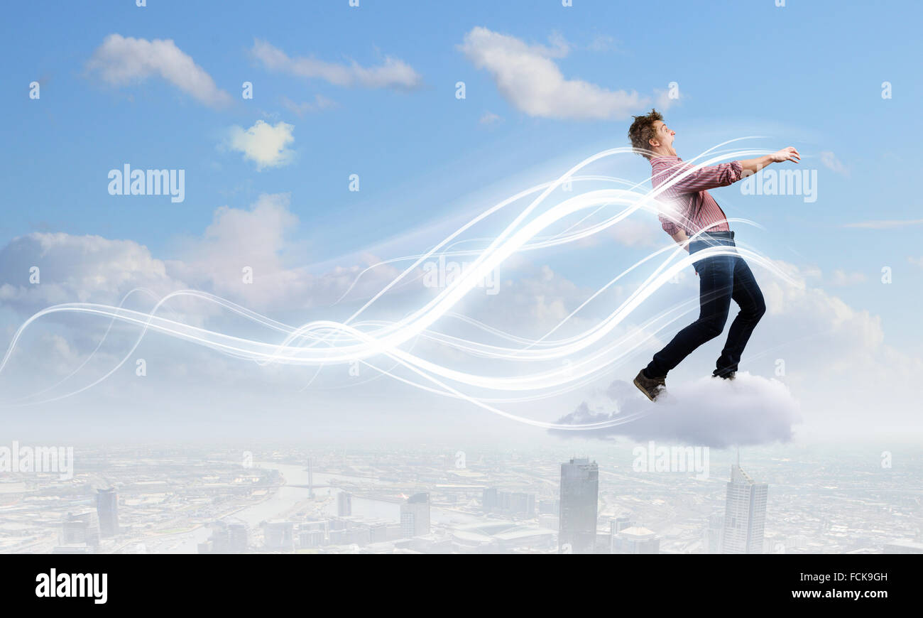 Young man walking on cloud high in sky Stock Photo - Alamy