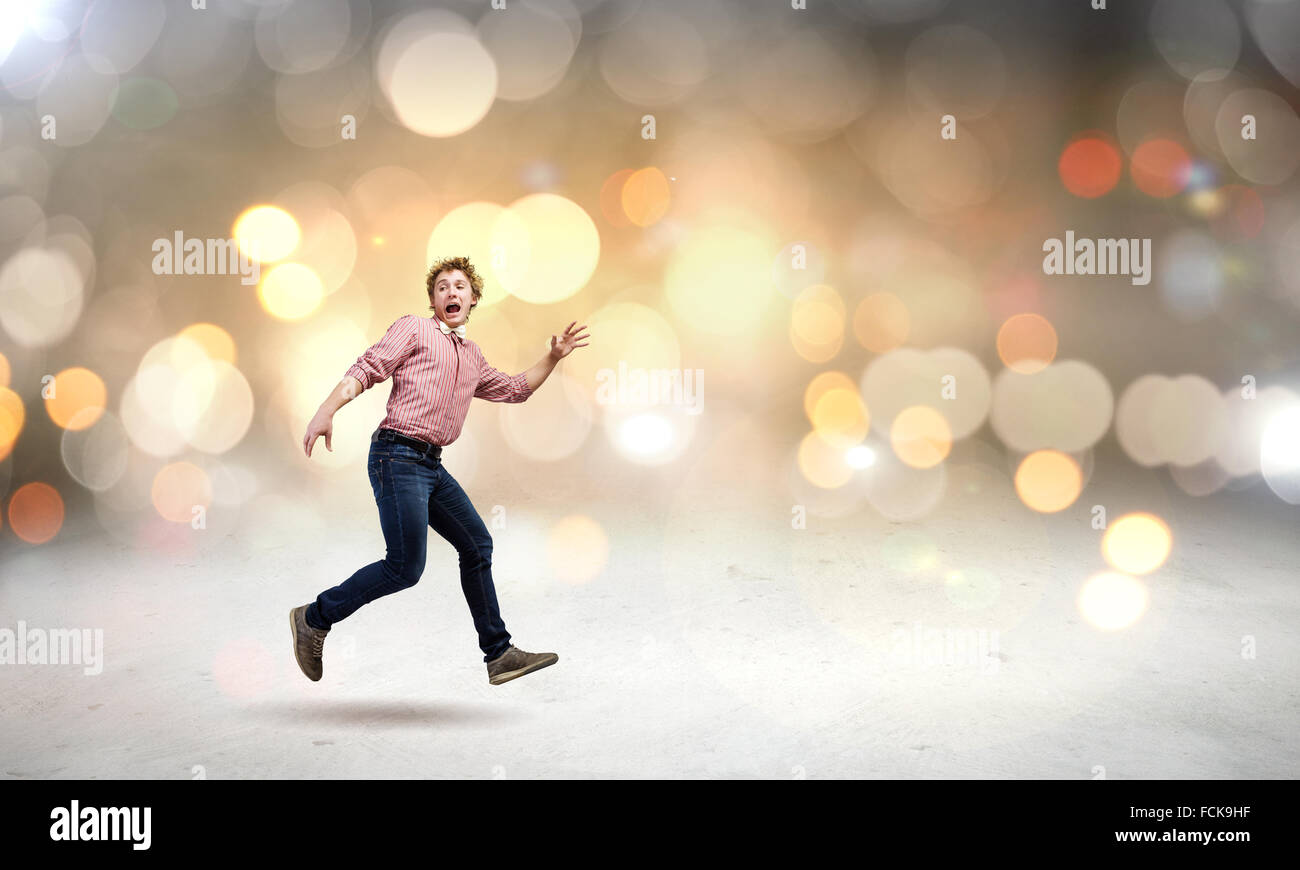 Young man in casual running away from something Stock Photo - Alamy