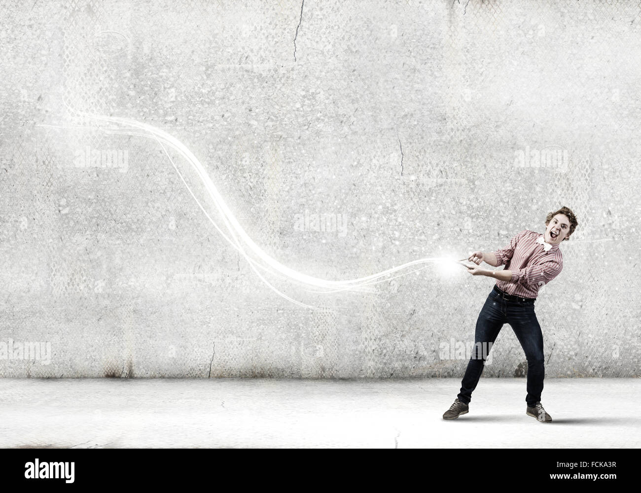 Young guy in casual pulling loop of light Stock Photo - Alamy