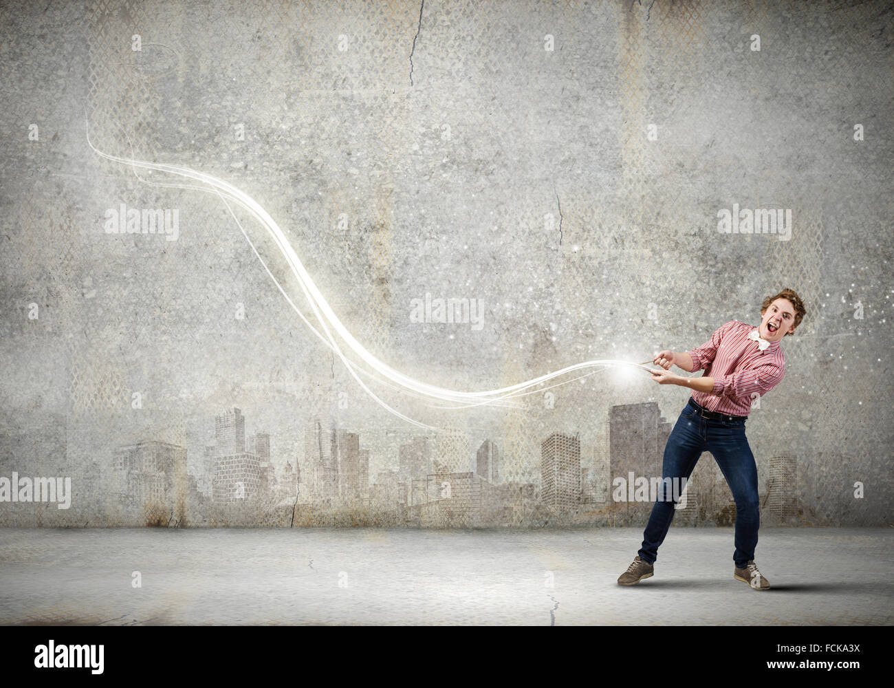 Young guy in casual pulling loop of light Stock Photo - Alamy