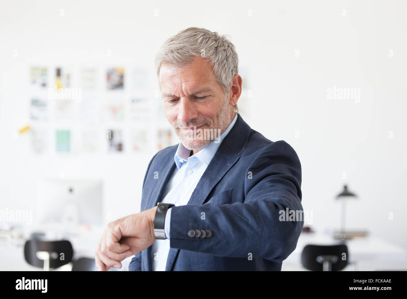 Businessman in office checking the time Stock Photo - Alamy