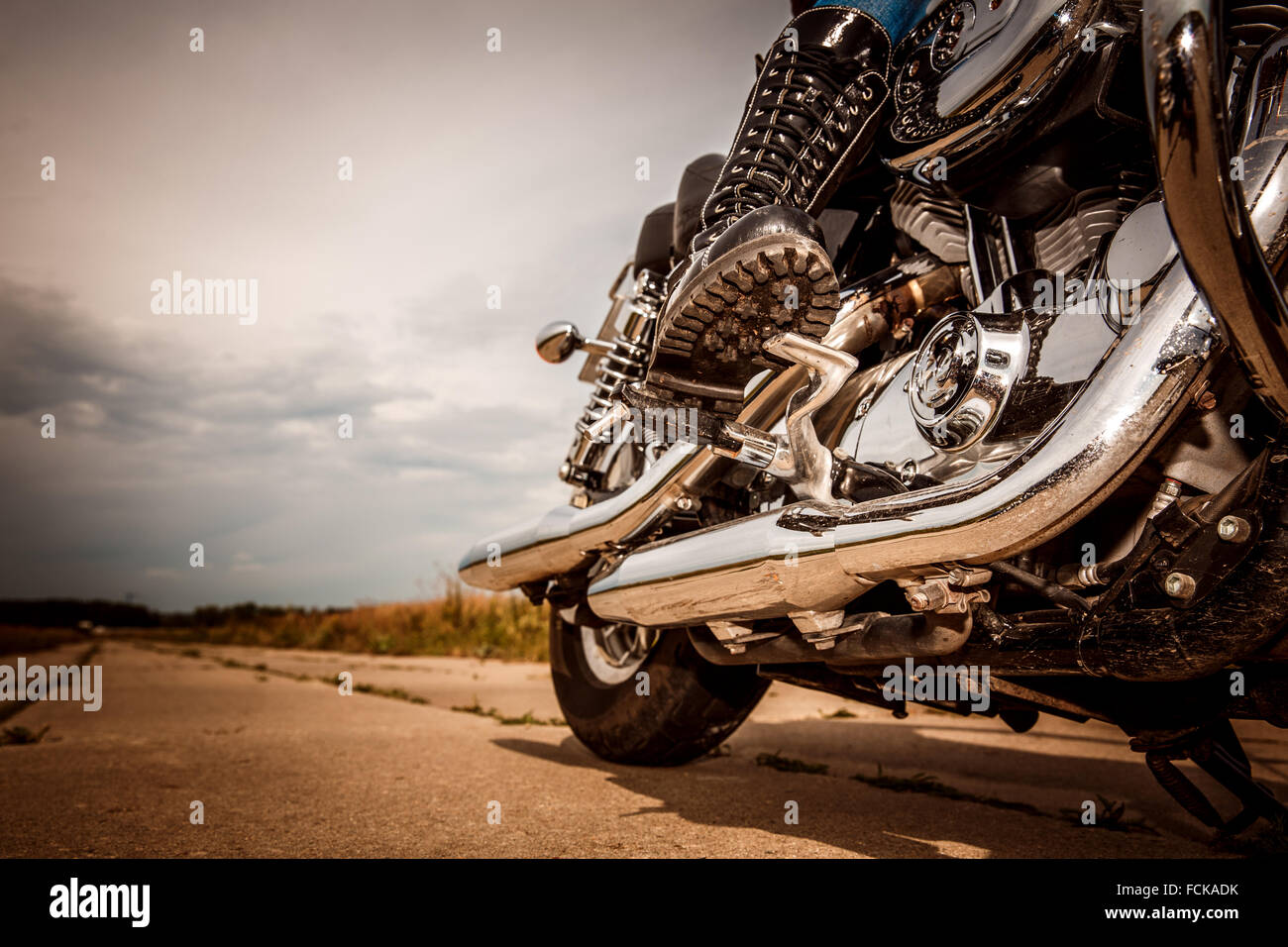 Biker girl riding on a motorcycle. Bottom view of the legs in leather ...