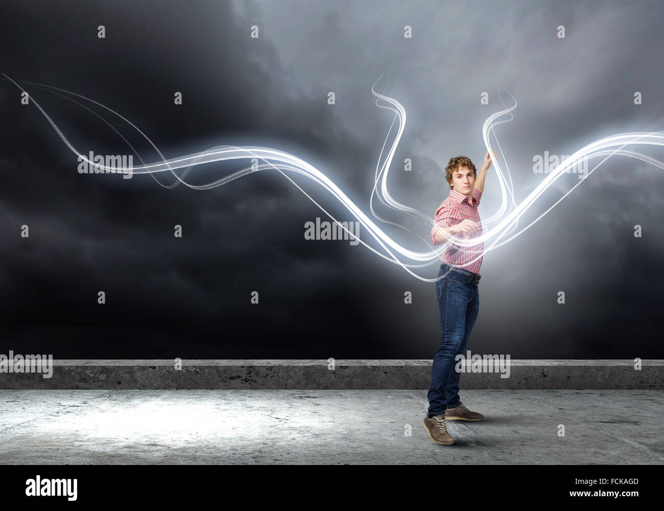 Young man in casual throwing magic light Stock Photo - Alamy