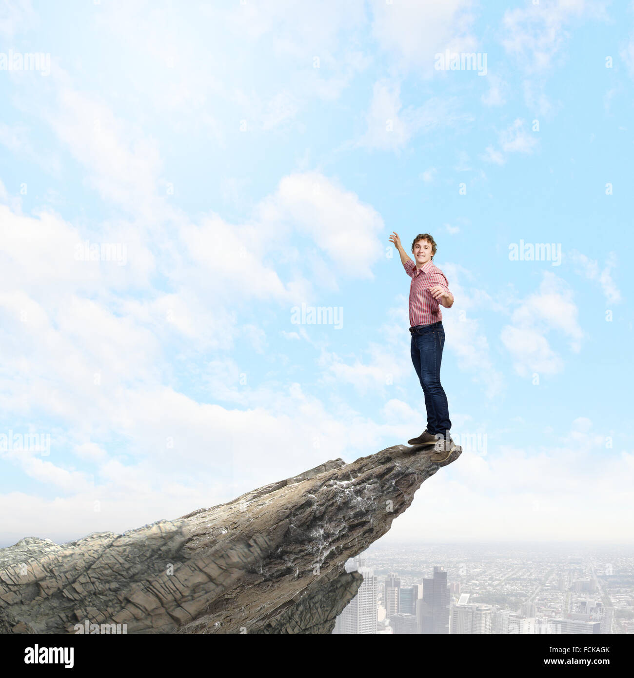 Young man balancing on one leg on edge of rock Stock Photo - Alamy
