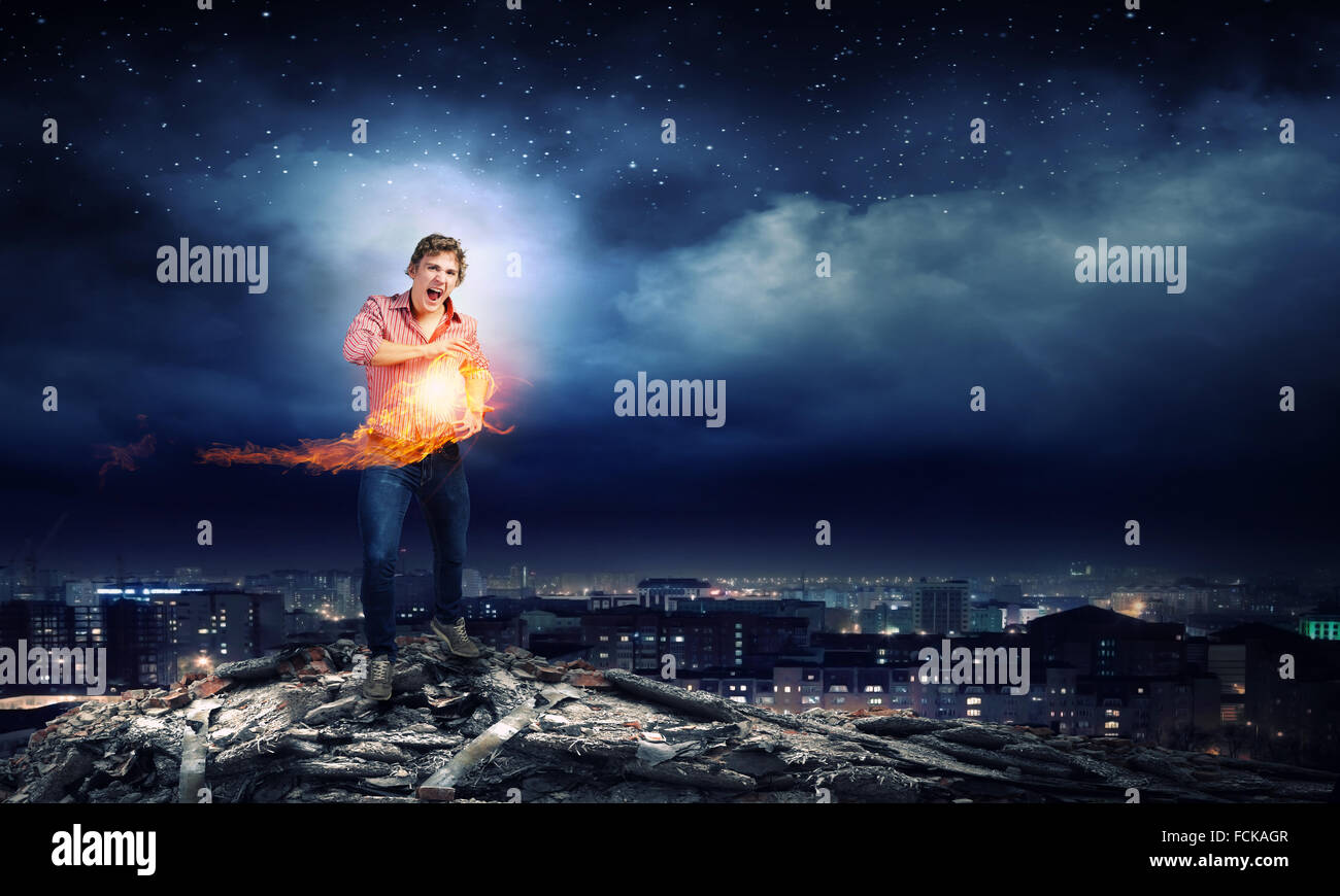 Young man in casual throwing magic fire balls Stock Photo - Alamy
