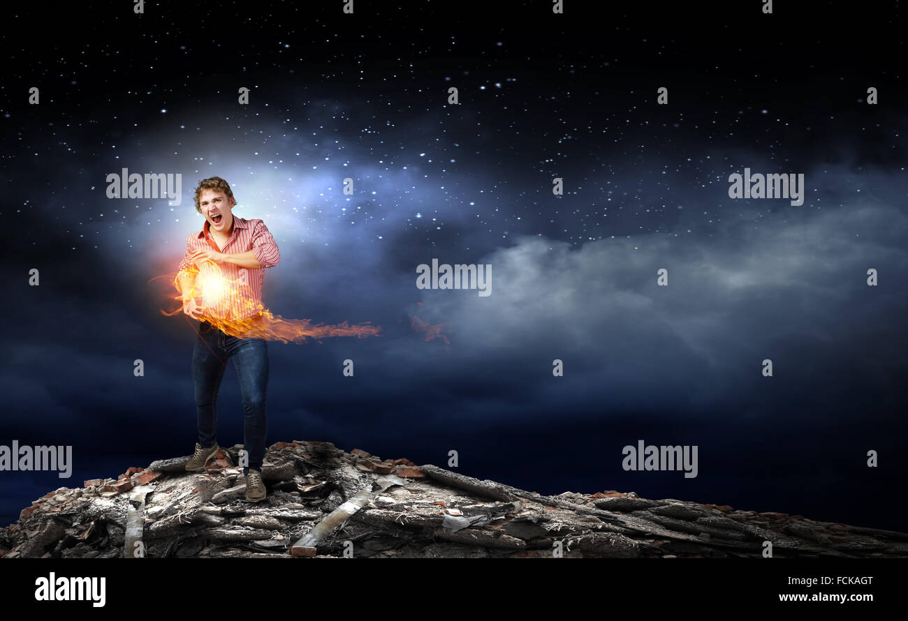 Young man in casual throwing magic fire balls Stock Photo - Alamy