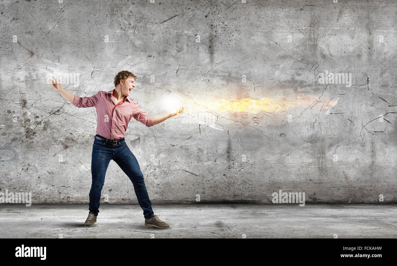 Young man in casual throwing magic light Stock Photo - Alamy