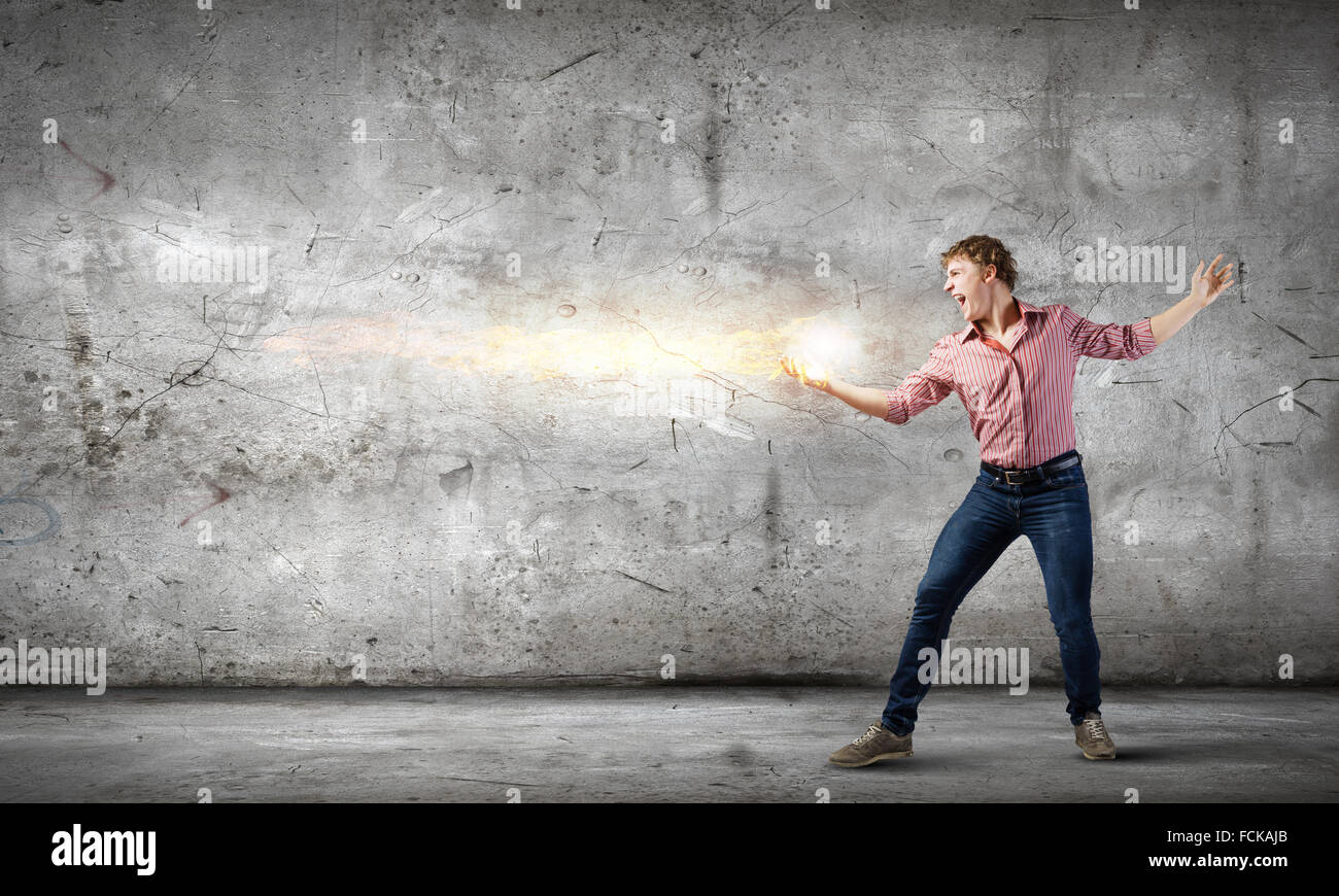 Young man in casual throwing magic fire balls Stock Photo - Alamy