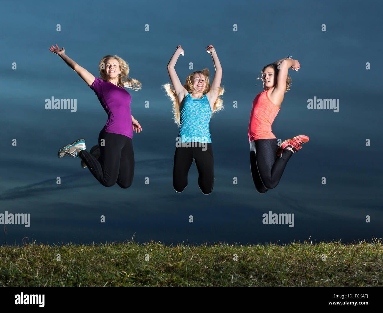 Three young women jumping together in the air Stock Photo - Alamy