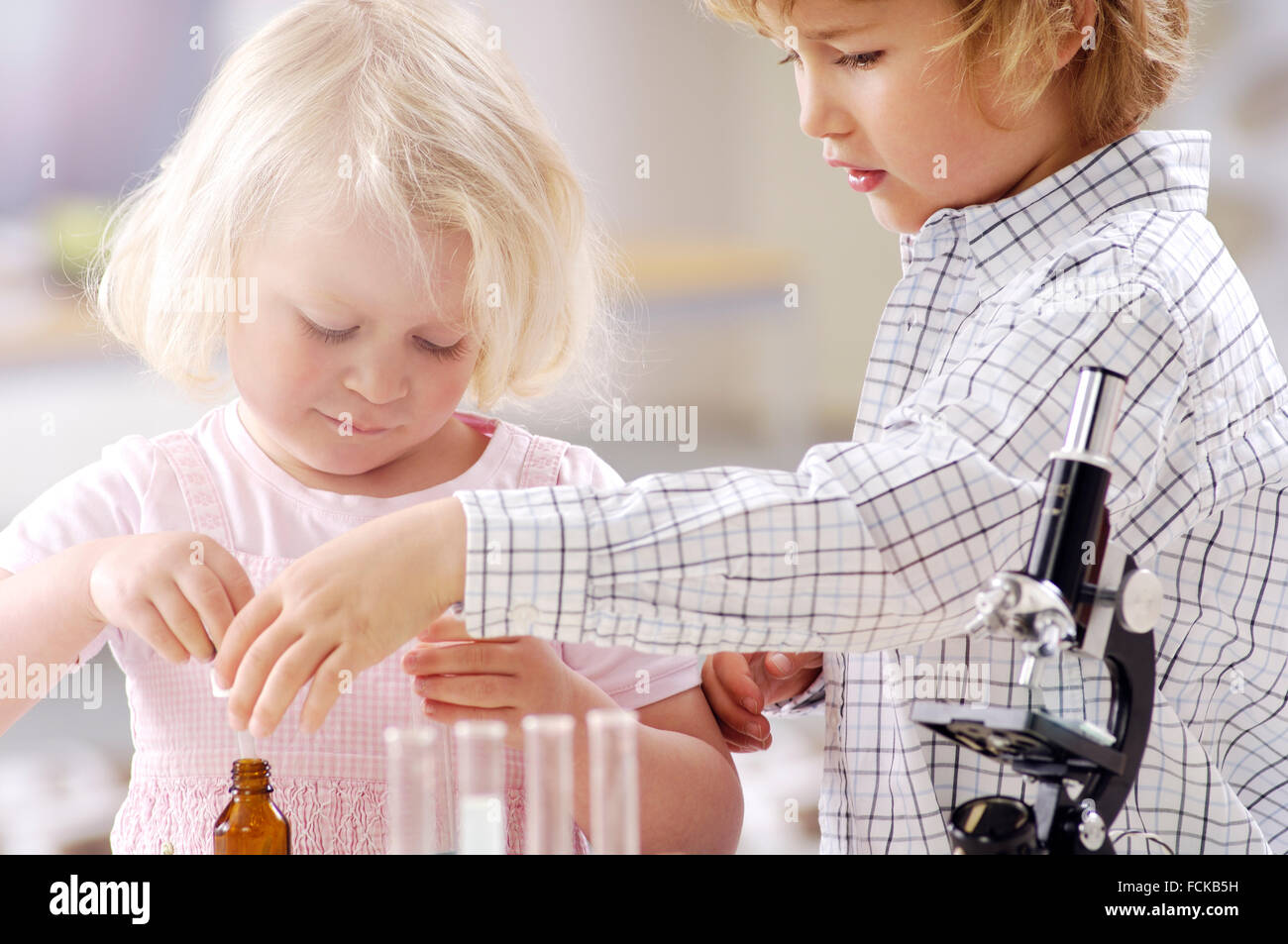 Two little children playing utensils of chemical laboratory Stock Photo ...