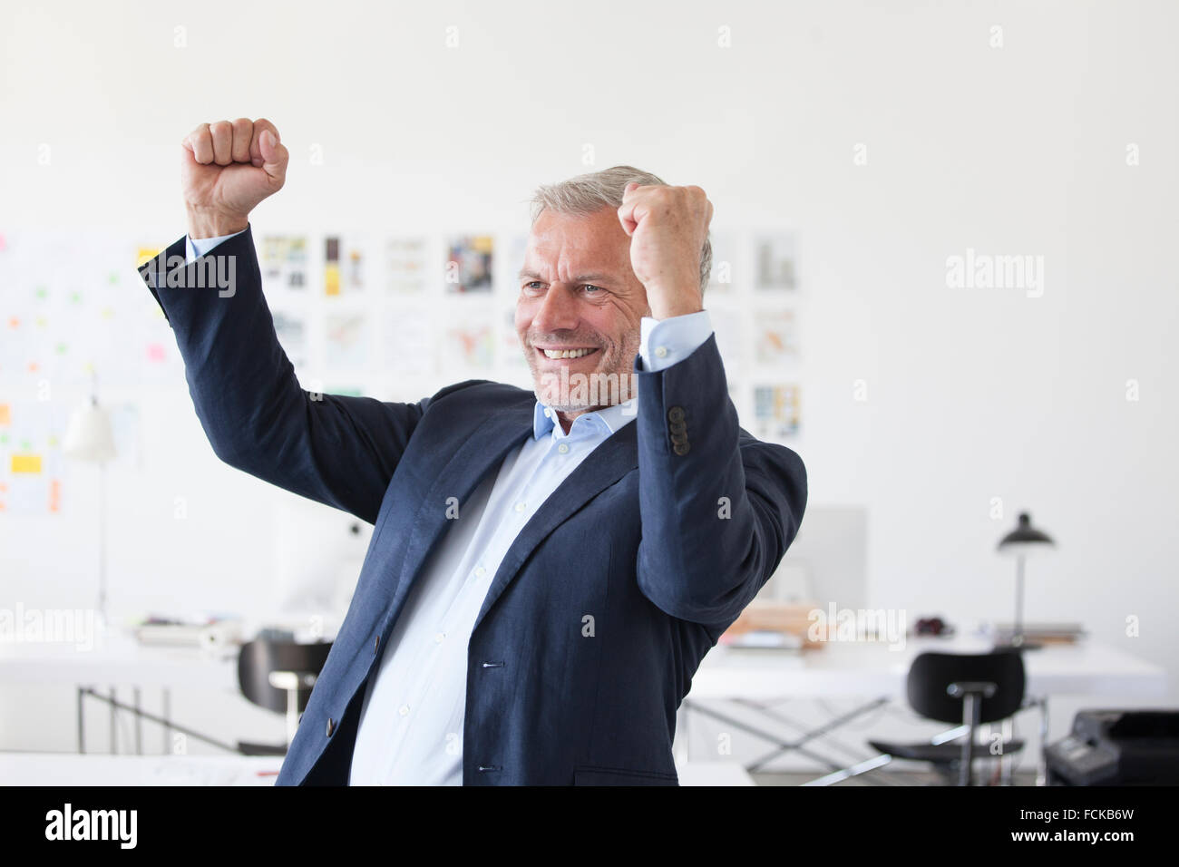 Businessman cheering in office Stock Photo - Alamy