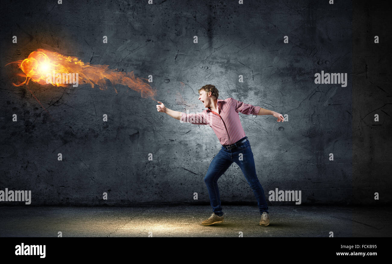 Young man in casual throwing magic fire balls Stock Photo - Alamy