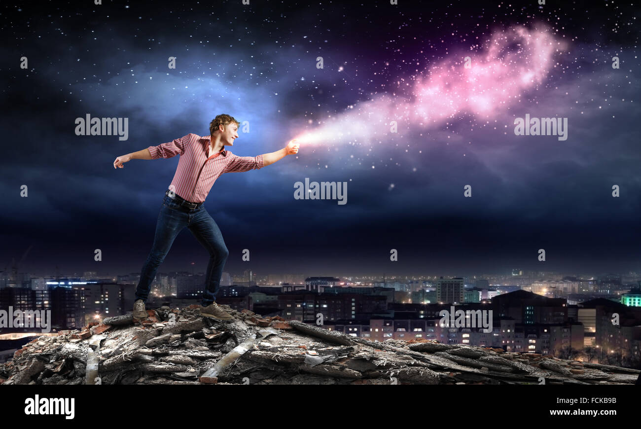 Young man in casual throwing magic light Stock Photo - Alamy