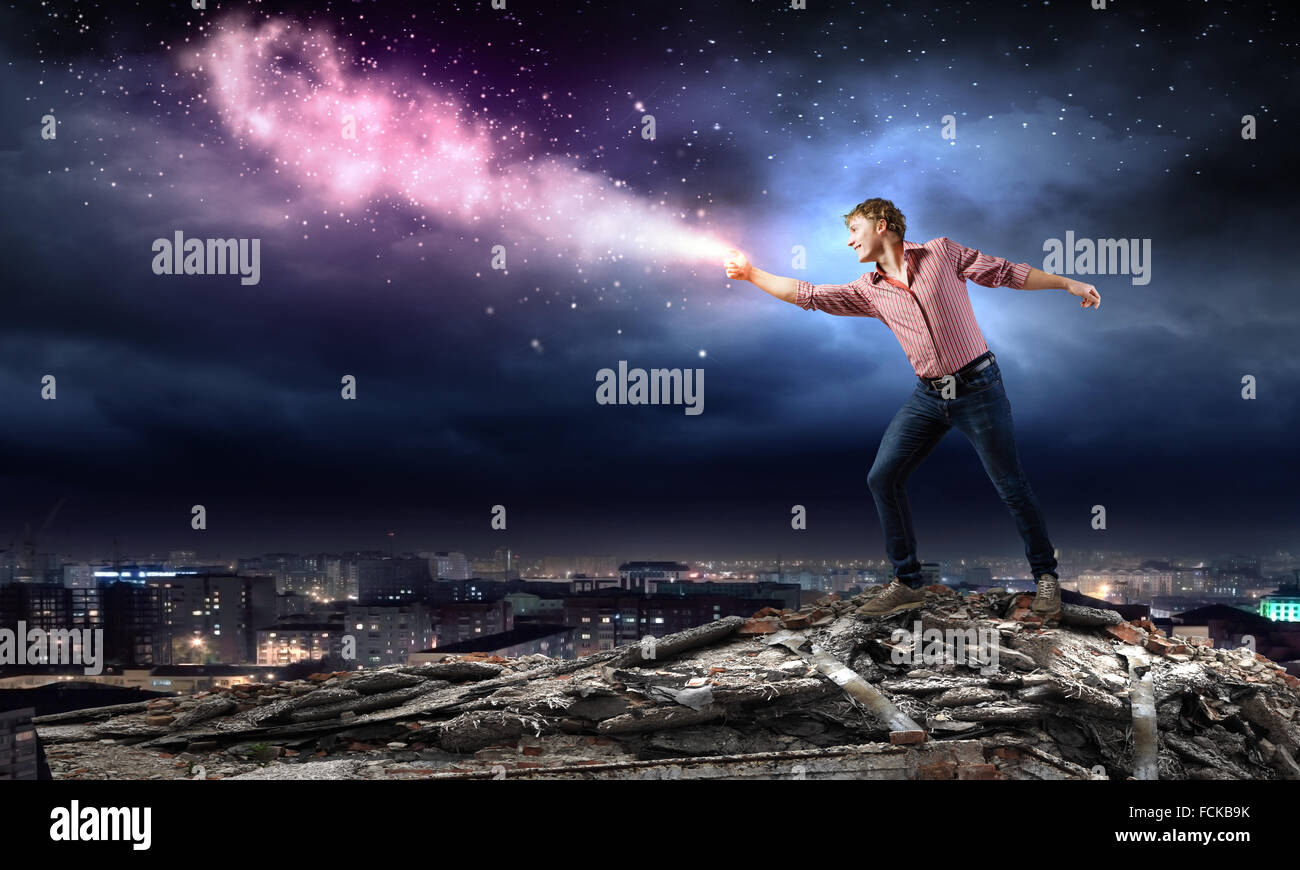 Young man in casual throwing magic light Stock Photo - Alamy