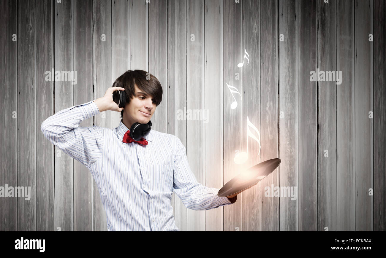 Young man dj wearing headphones and holding plate Stock Photo - Alamy