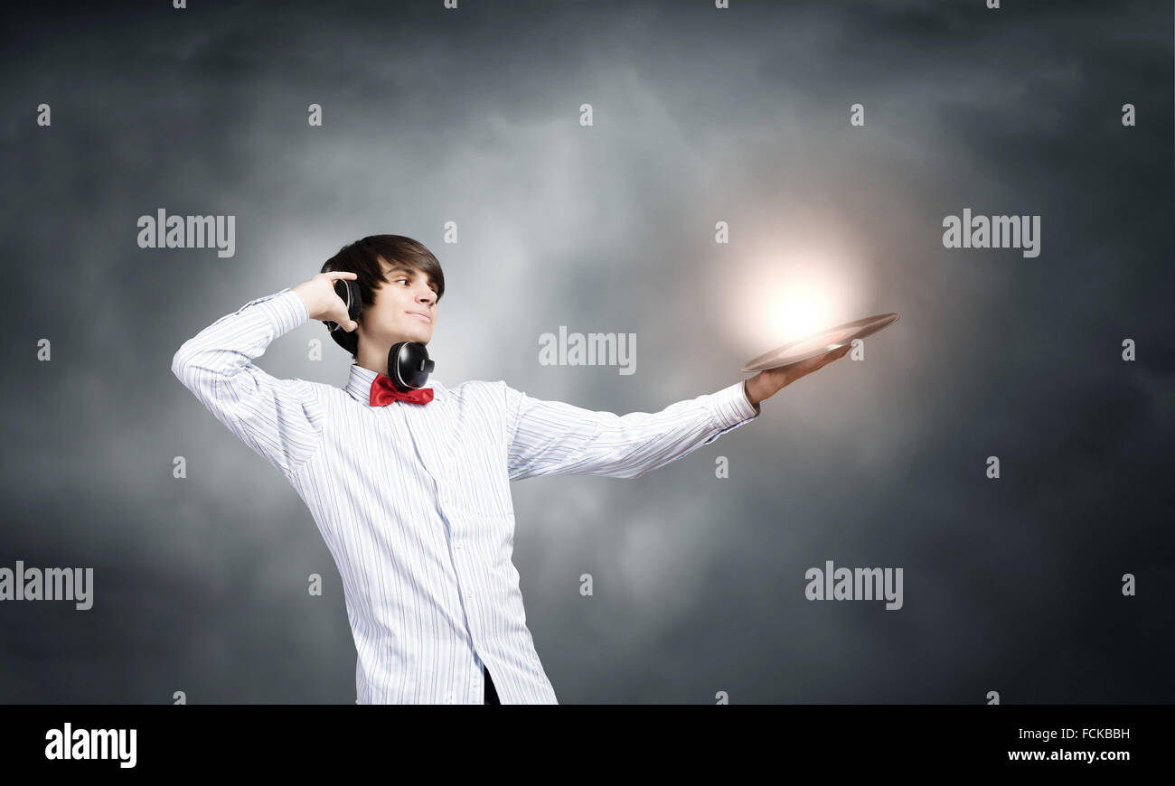 Young man dj wearing headphones and holding plate Stock Photo - Alamy