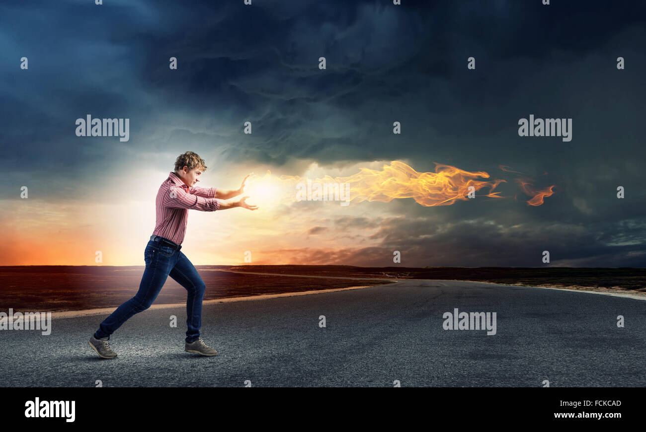 Young man in casual throwing magic fire balls Stock Photo - Alamy